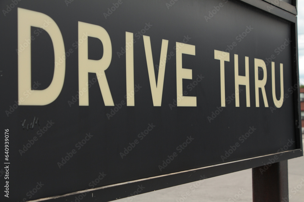 drive thru sign in white capital letters on black background with black ...