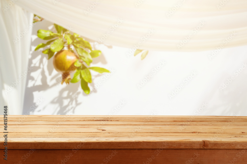 Jewish holiday Sukkot concept. Empty wooden table over pomegranate tree ...