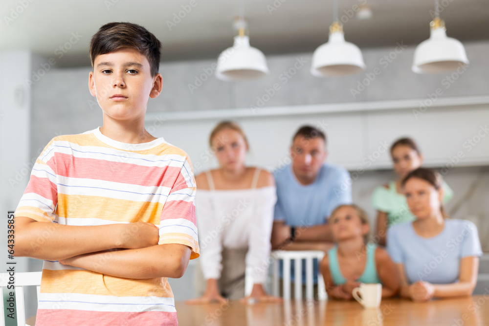 Sullen boy child crossed arms crossed over chest and is standing with ...