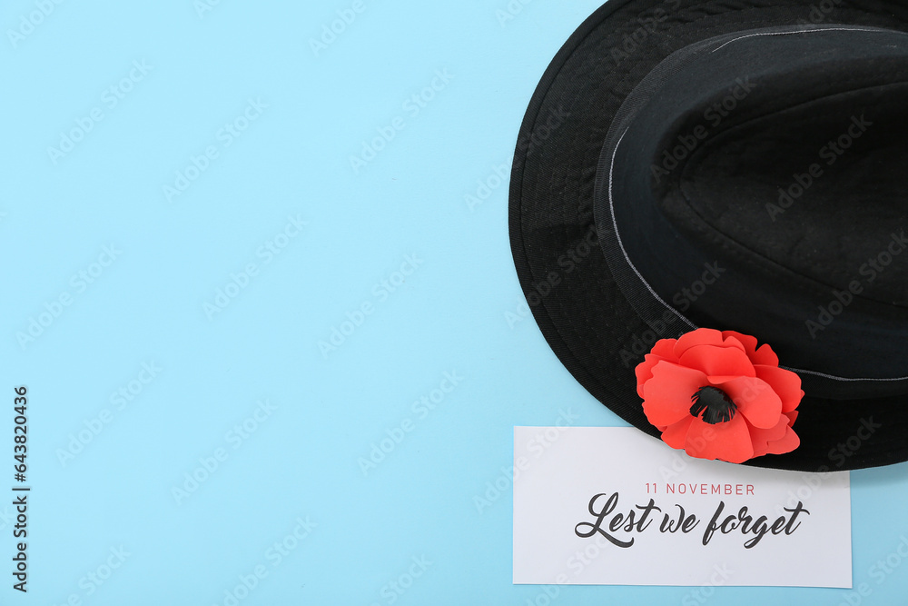 Poppy flower, hat and card with text LEST WE FORGET on blue background ...