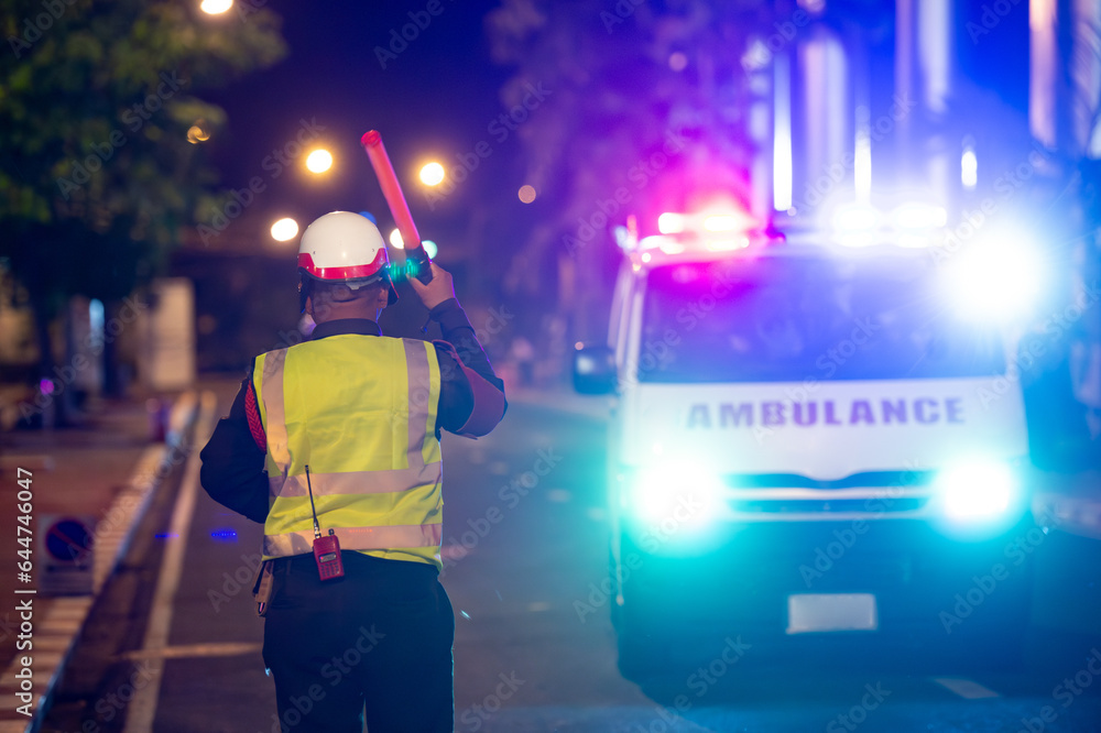 Security officers are using traffic batons to facilitate an ambulance ...