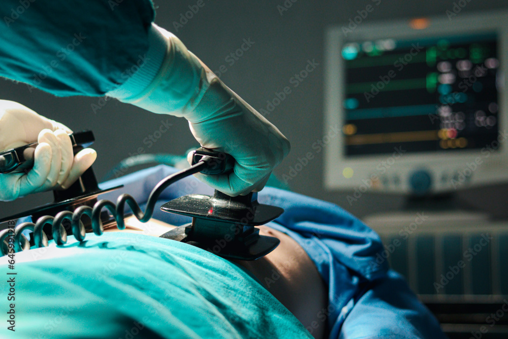 Surgeon doctor hand hold defibrillator to pump chest heart patient to save life sick people in ...