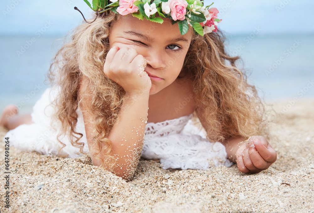 Portrait of a cute young girl laying on beach making a face; Waikiki ...