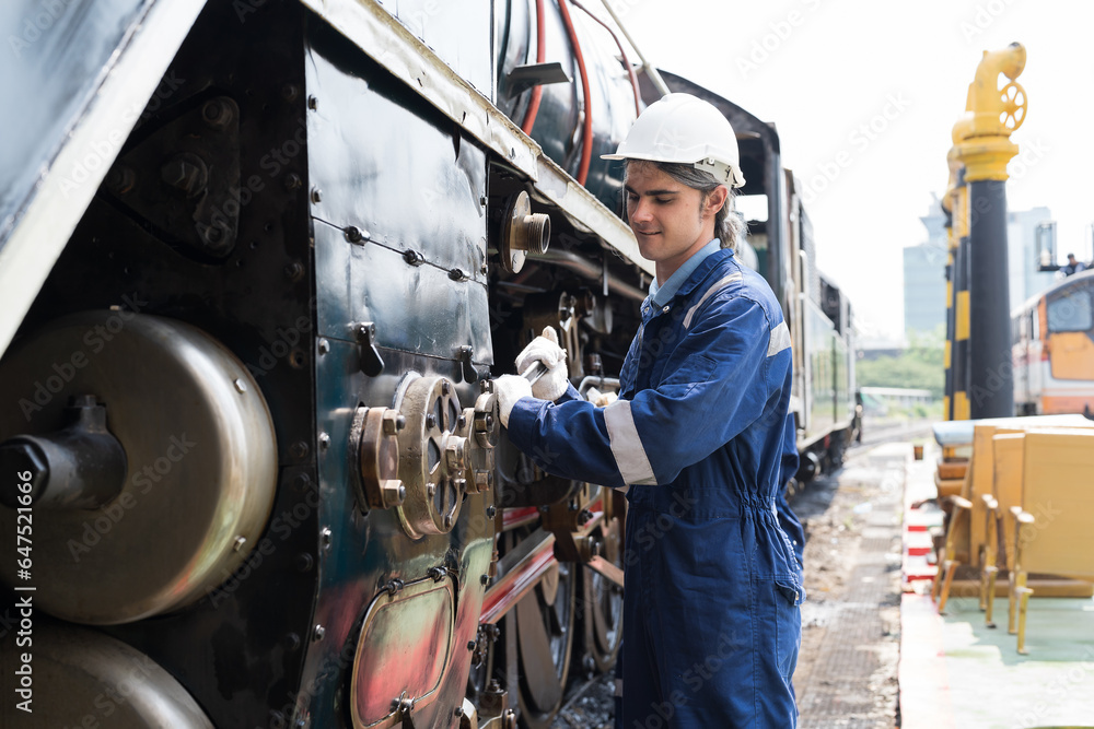 Male engineer maintenance locomotive engine, wearing safety uniform ...