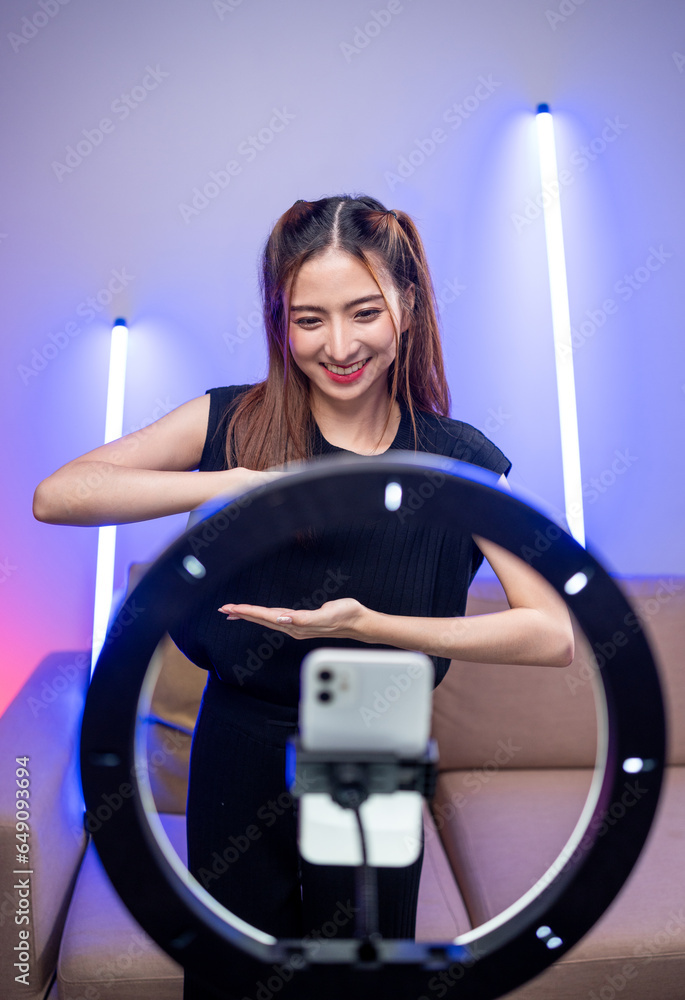 Young trendy influencer asian woman dancing on mobile phone at home in ...