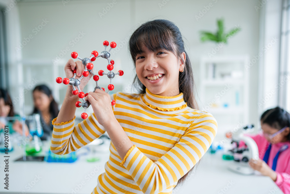 Little girl having fun time with holding molecular model learning ...