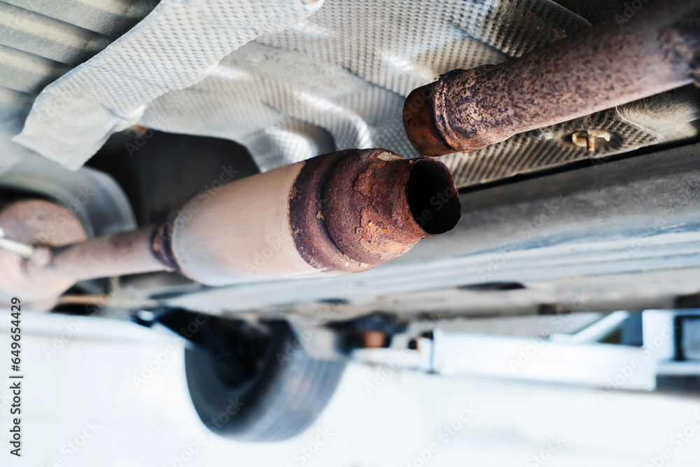 Broken car muffler. Rusty resonator of the sound absorption system ...