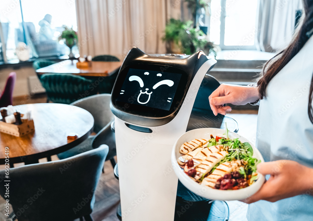 Robot waiter serve food at modern restaurant table.Offering innovation ...