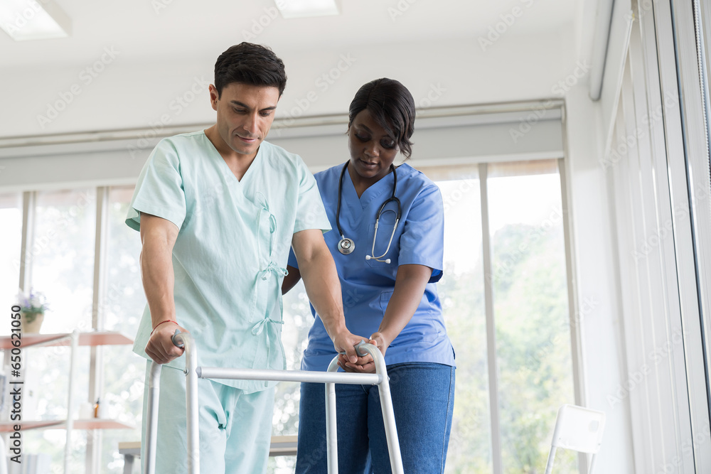 Young female nurse help patient man walk with walker careful at ...