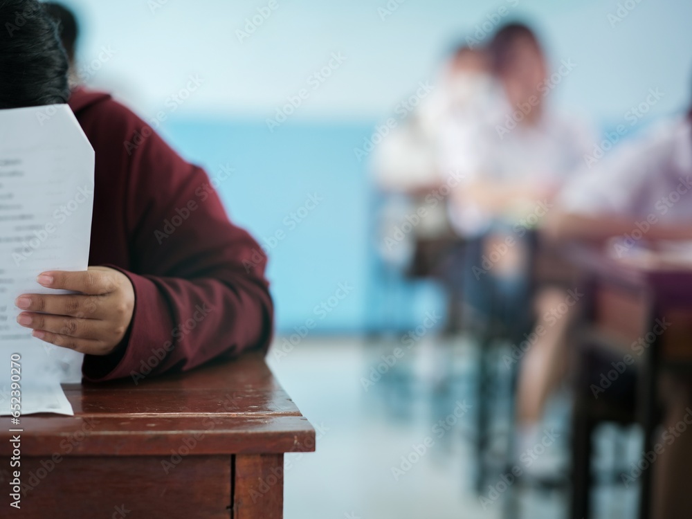 Students reading exam answer sheets exercises in classroom of school ...