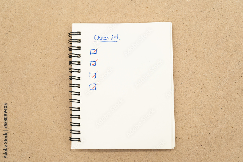 Top view of notebook with handwritten Checklist text. Checklist concept ...