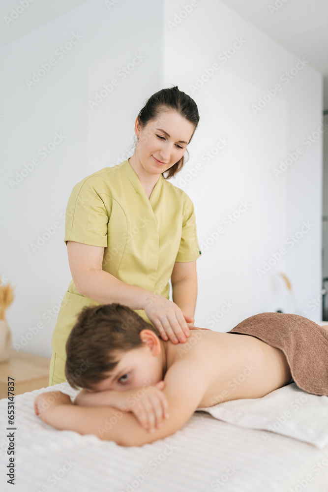 Vertical portrait of professional female masseuse massaging neck ...