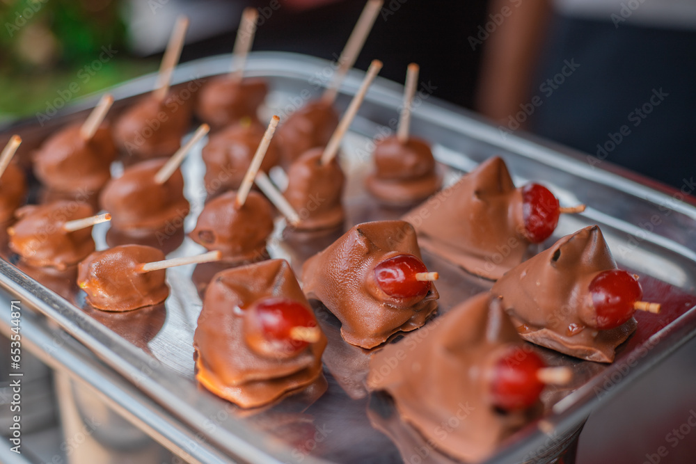 Chocolate flavored betel leaf on ice stuffed with cherry known as ...