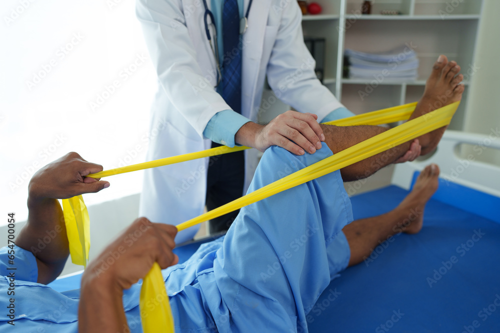 Physical therapist gives resistance band therapy to the legs and knees ...
