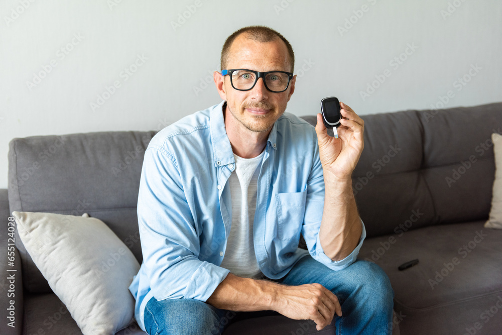 Diabetic patient man using glucose meter for measuring and monitoring ...