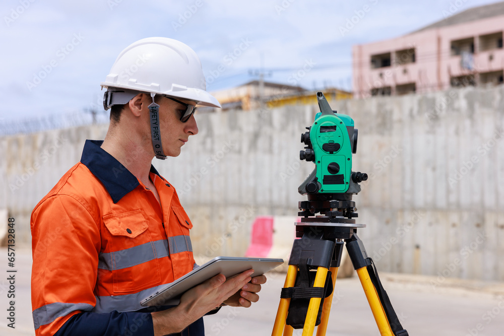 Engineer use theodolite equipment and looking blueprints on tablet ...
