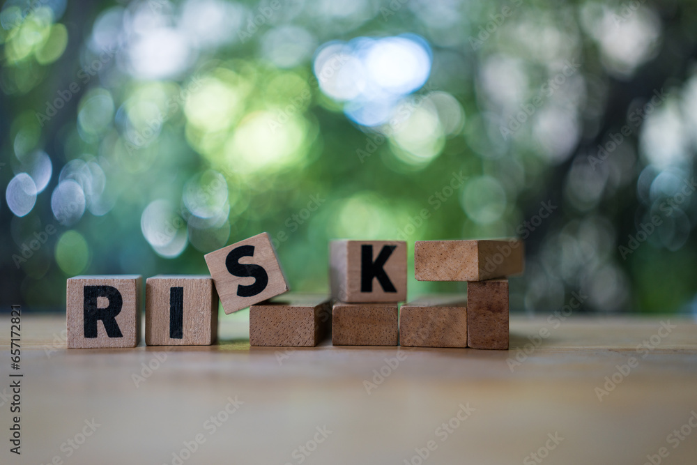 Four wood cubes with black letters spelling RISK. Risk Management and ...