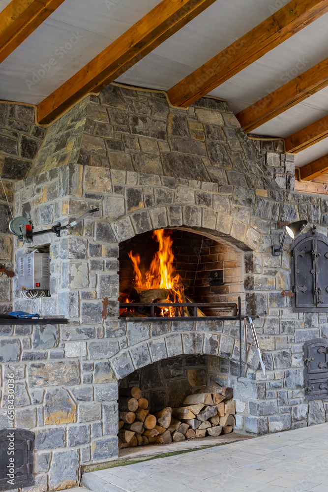 Burning stone barbecue firewood with fire, open brick oven for cooking ...
