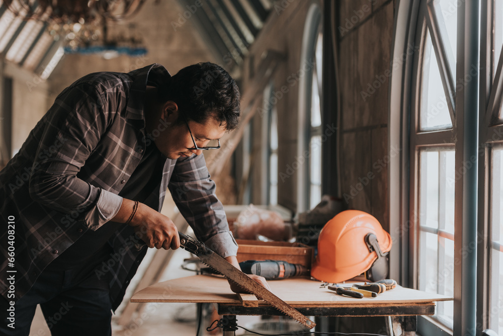 Carpenter Cutting wood on the table, The workshop looks professional ...