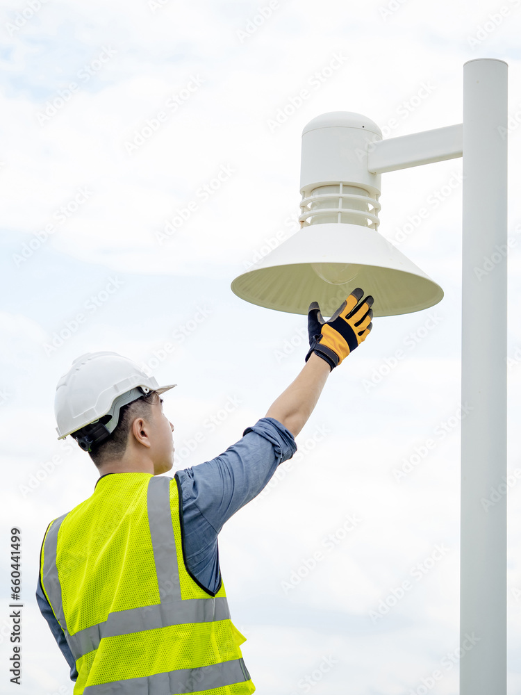 Asian male electrician installing street light pole .Maintenance worker ...