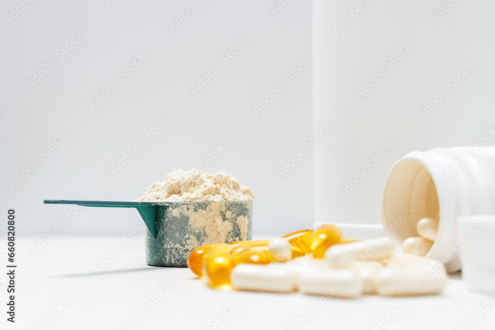 Foto de Stock Whey protein powder in measuring spoon, white capsules of ...