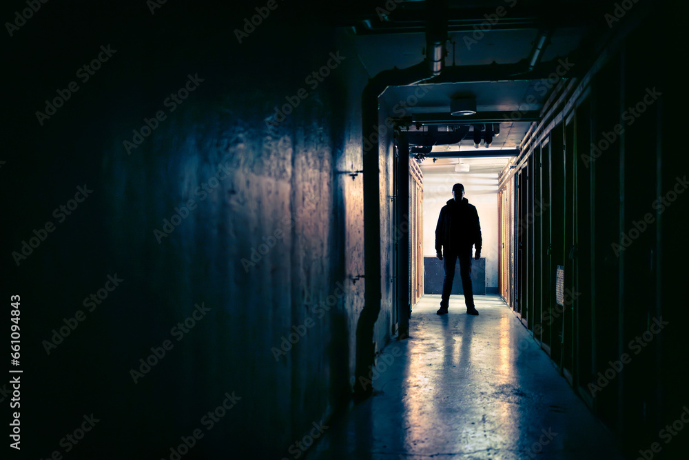 Killer, creepy, scary stalker man in dark corridor. Horror, thriller movie concept. Suspicious ...