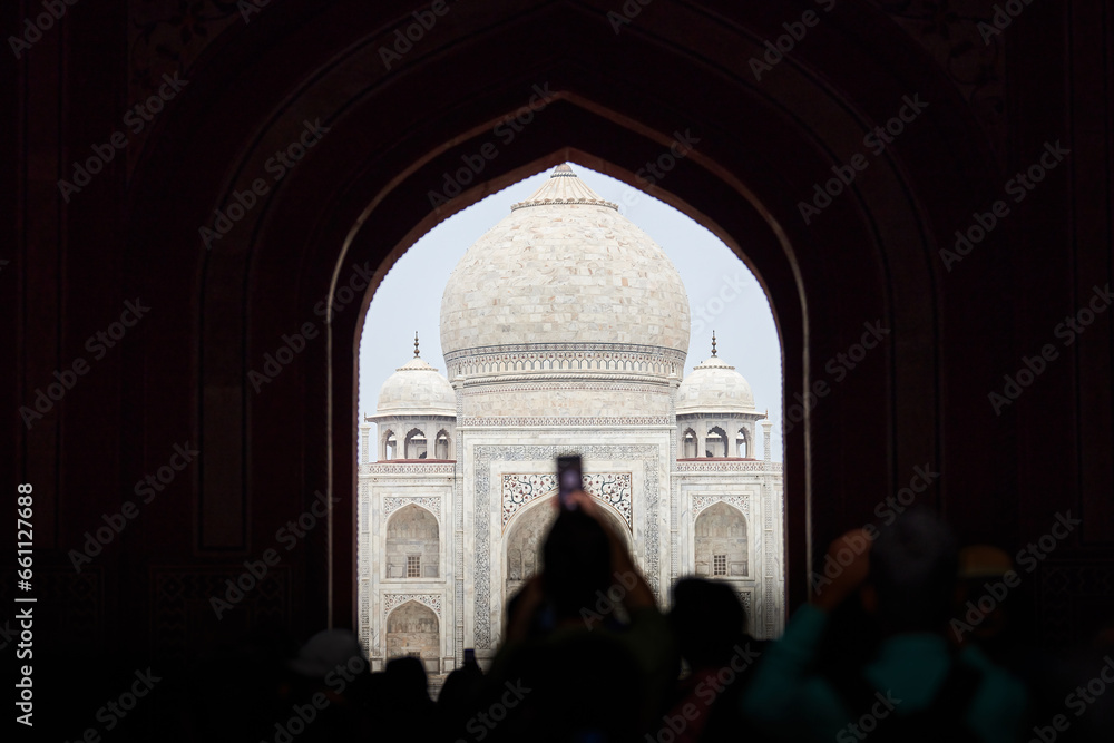 Archway of main gateway in Taj Mahal entrance with tourists silhouettes ...