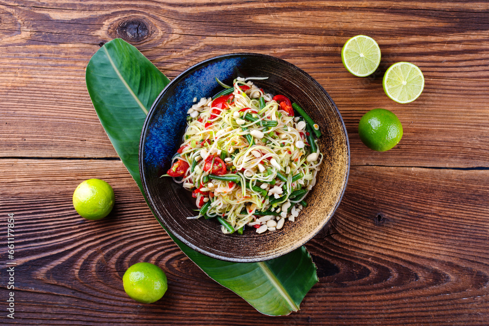 Traditional Thai green papaya som tam salad with green papaya slices ...
