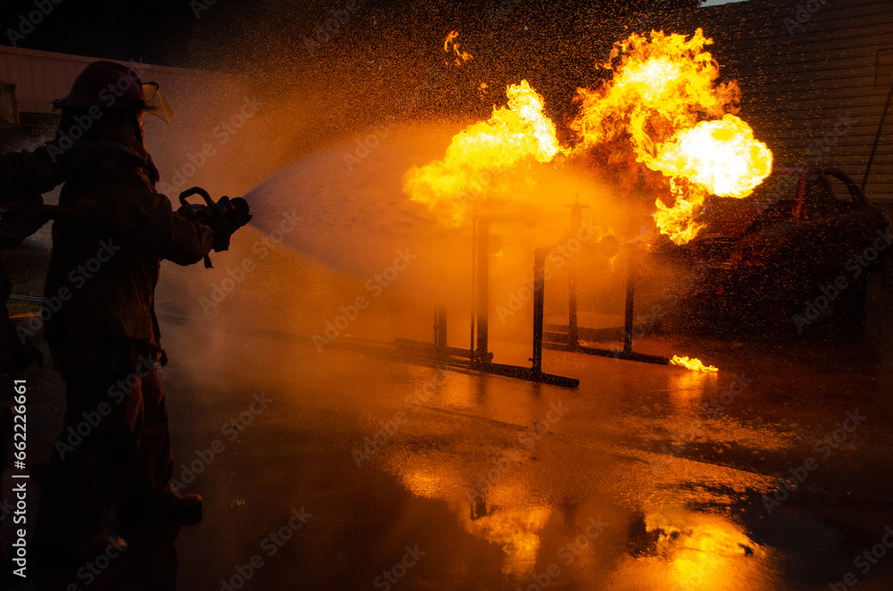 Car fire. Firefighters use a chemical foam extinguisher from a car ...