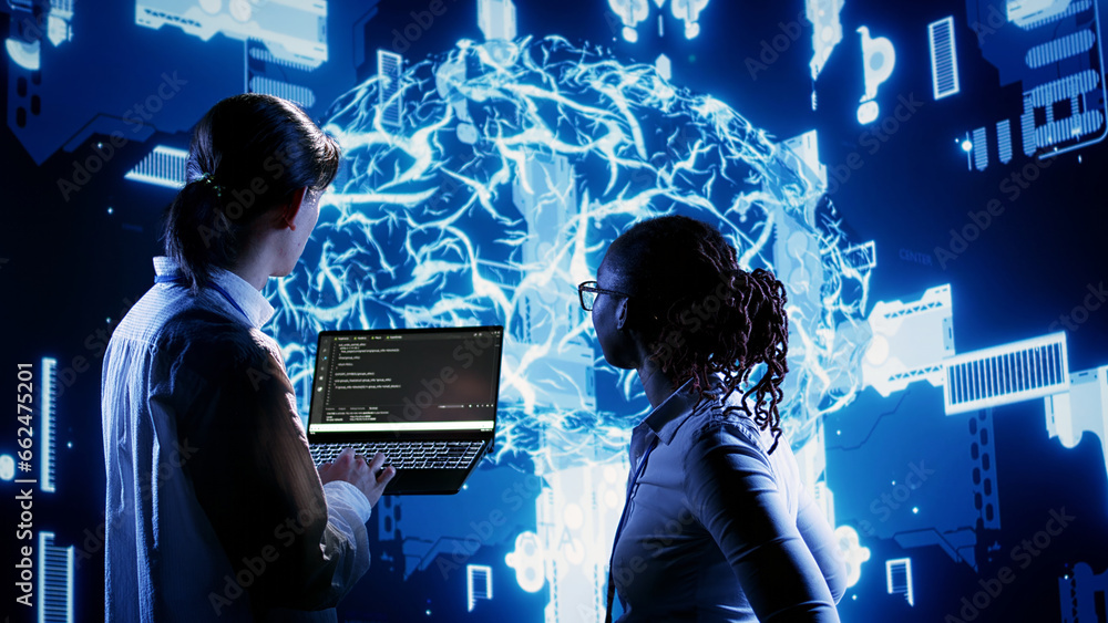 Proactive IT coworkers programming scripts on laptop, employing AI machine learning. Efficient ...