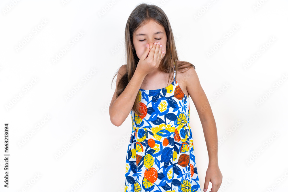 Beautiful little kid girl wearing colorful dress smelling something ...