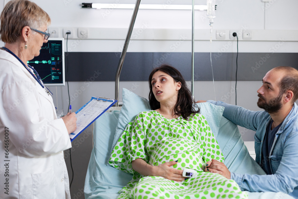 Doctor explaining labor symptoms to pregnant woman before medical ...