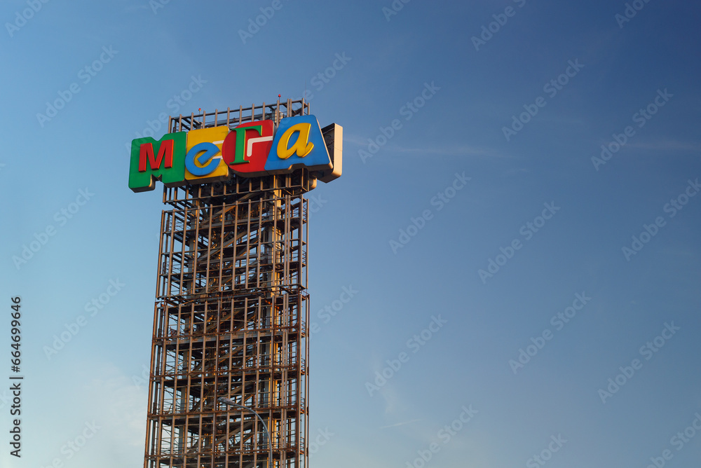 Billboard for a chain store with the words "Mega" on a tall metal truss ...