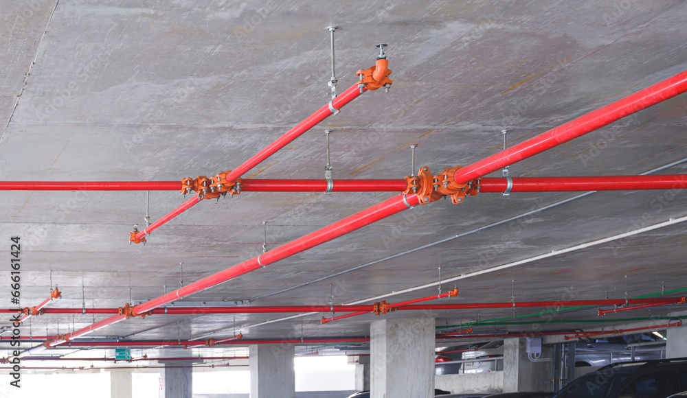 Red fire protection water pipeline system with sprinkler on concrete ...