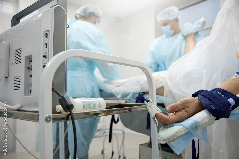 Process of operation by team surgeons, patient's hand is tied and ...