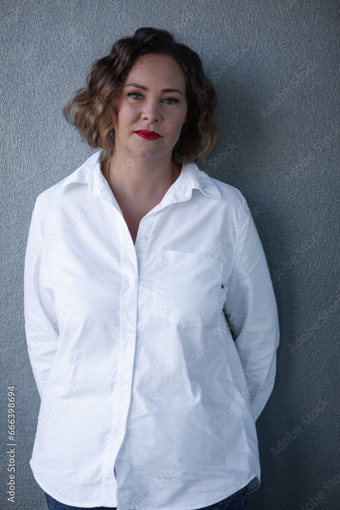 Beautiful fat woman posing against grey wall. The plus size model ...