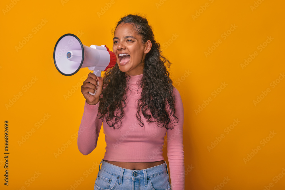 Young loud angry Indian woman holds megaphone in hand and screams ...