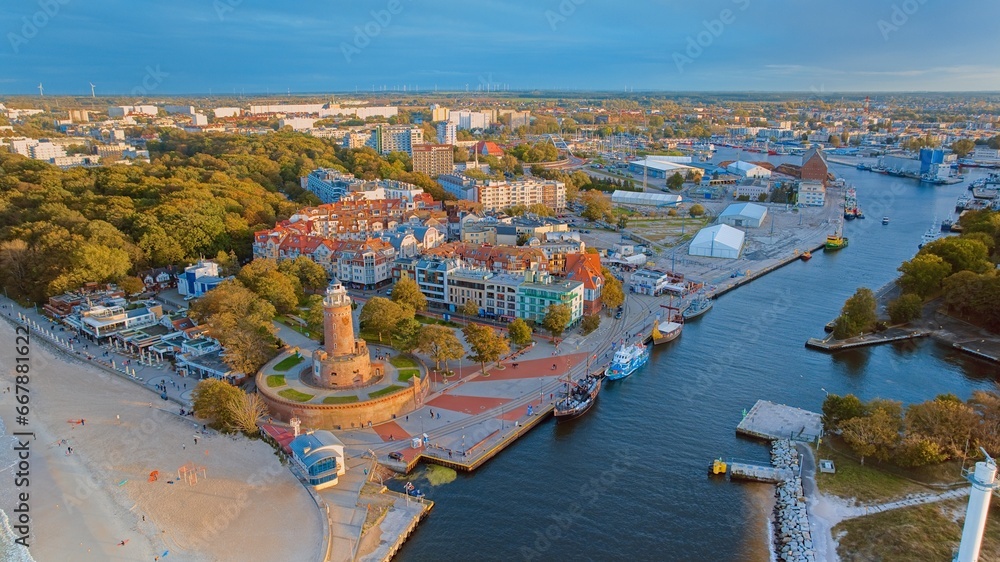 This aerial shot focuses on Kołobrzeg's iconic lighthouse and the ...