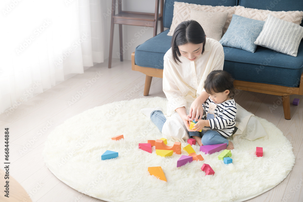 Parents and children playing together in a room in close proximity ...