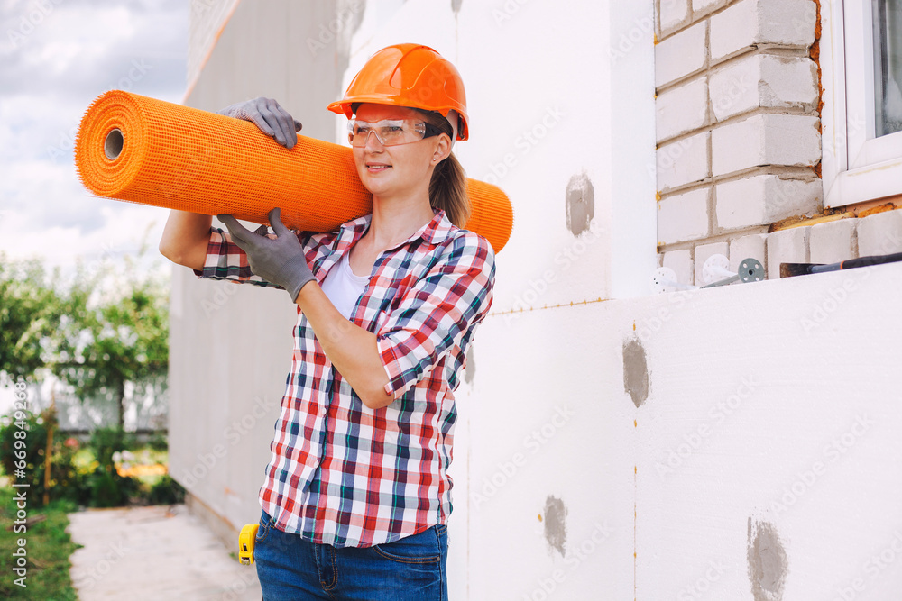 The woman with rolls of reinforcing fiberglass. Insulation of the house ...