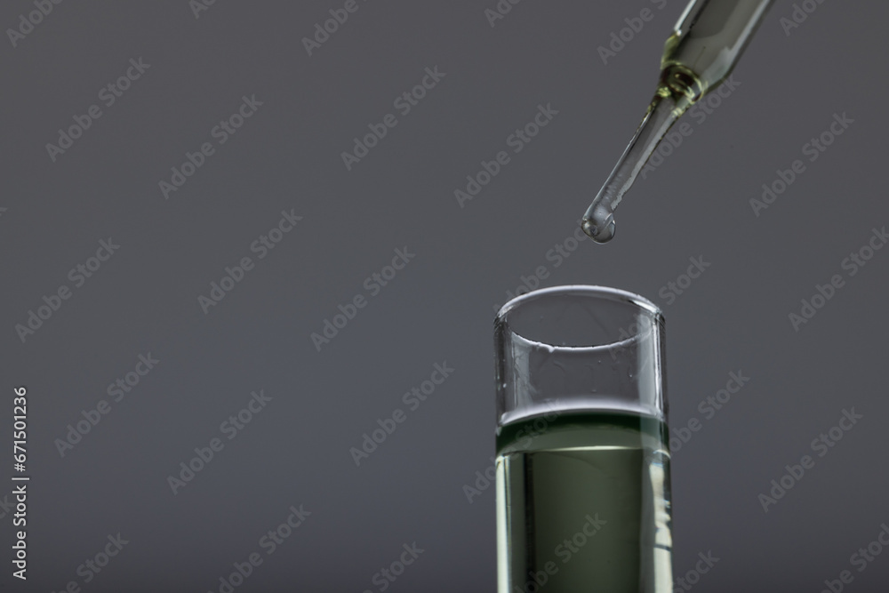 Vertical image of close up of laboratory test tube and pipette with ...