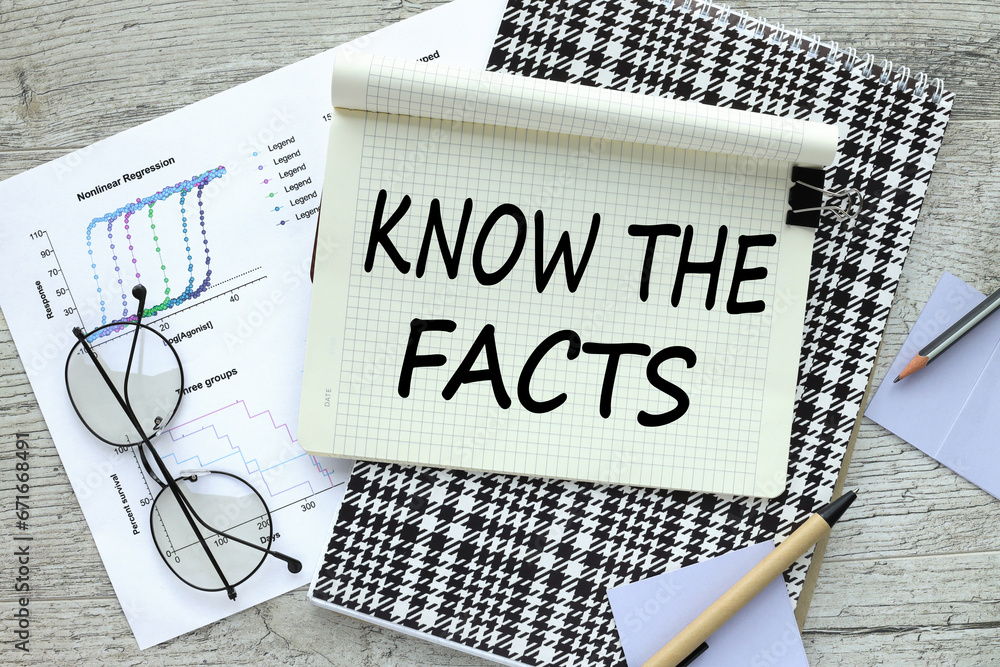KNOW THE FACTS several notepads on the work table. text on the page ...