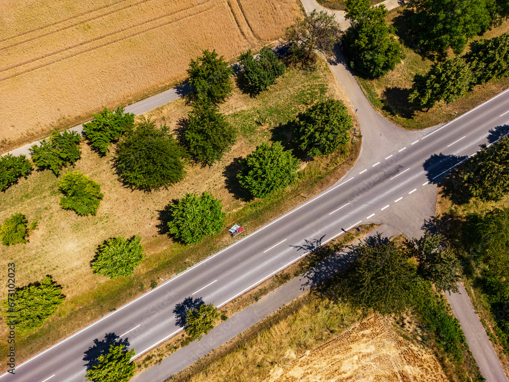 Straße mit Radweg kreuzt einen Feldweg auf dem Land Stock Photo | Adobe Stock