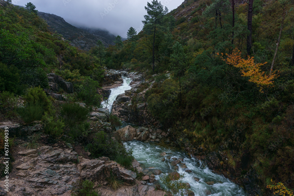 Small waterfall Cascata da Portela do Homem and mountain river with ...