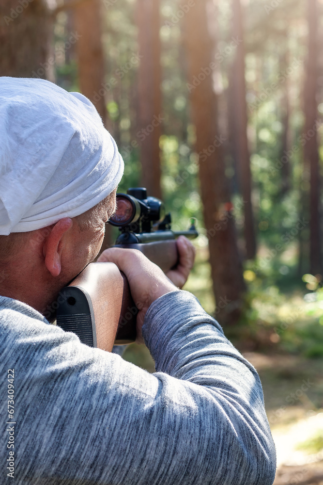 The man aimed into the distance with the help of an optical sight. Back ...