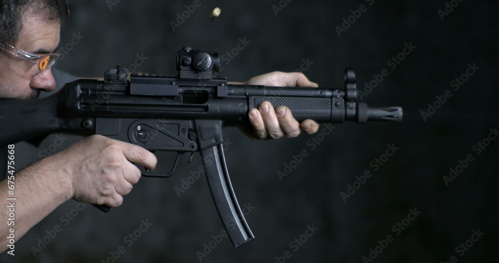 Firing weapon in high-speed, HK SP5K GUN side view. Person aiming and ...