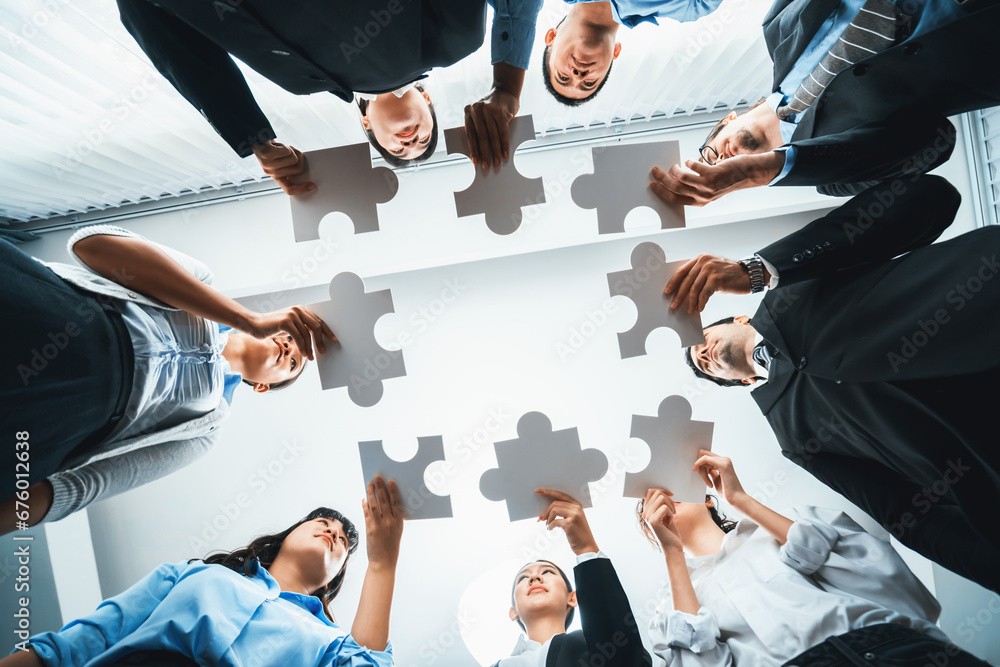 Multiethnic business people holding jigsaw pieces and merge them ...