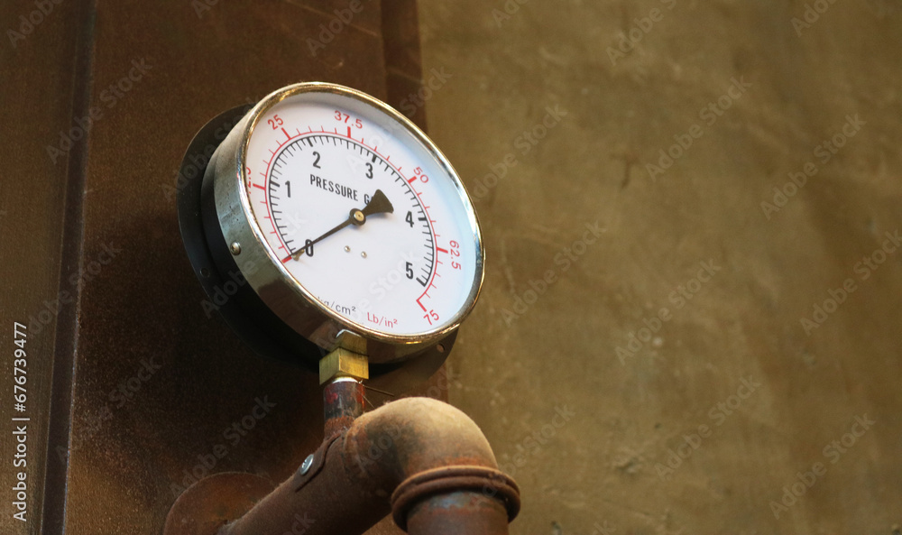 Pressure gauge meter installed on the wall. Stock Photo | Adobe Stock
