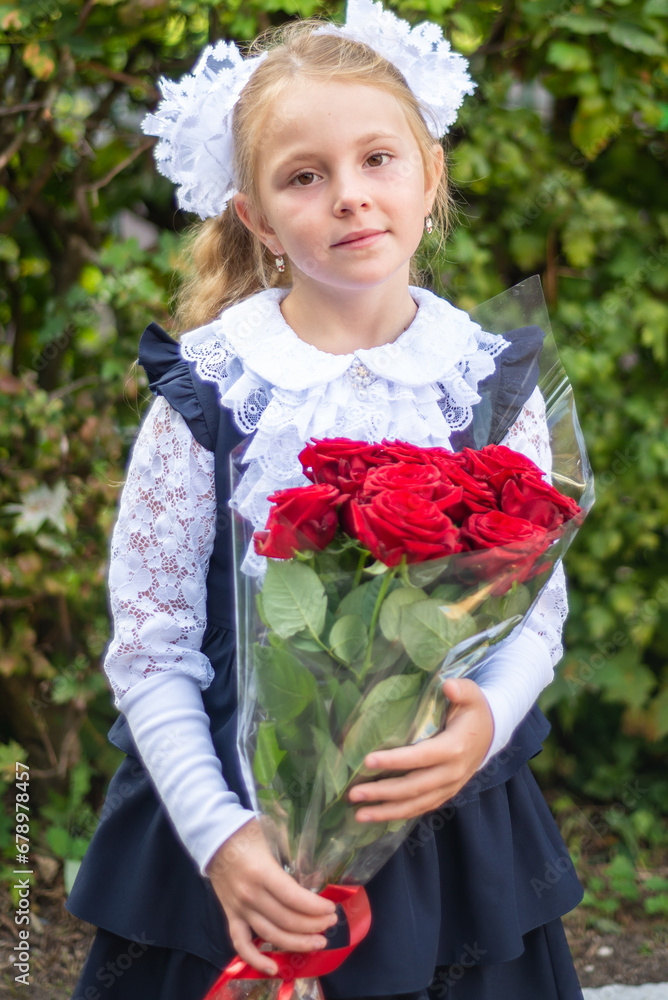The first time in the first class! A first-grader girl in a beautiful ...