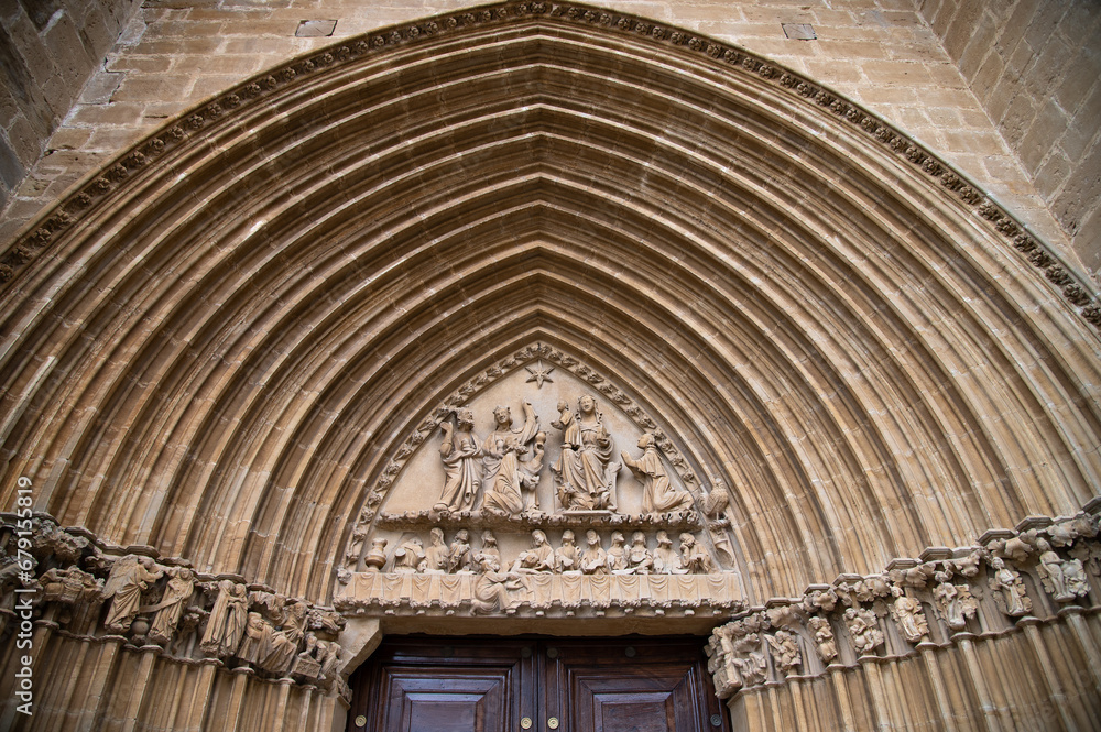 Vista del arco gótico de entrada y el tímpano con la escena de la ...